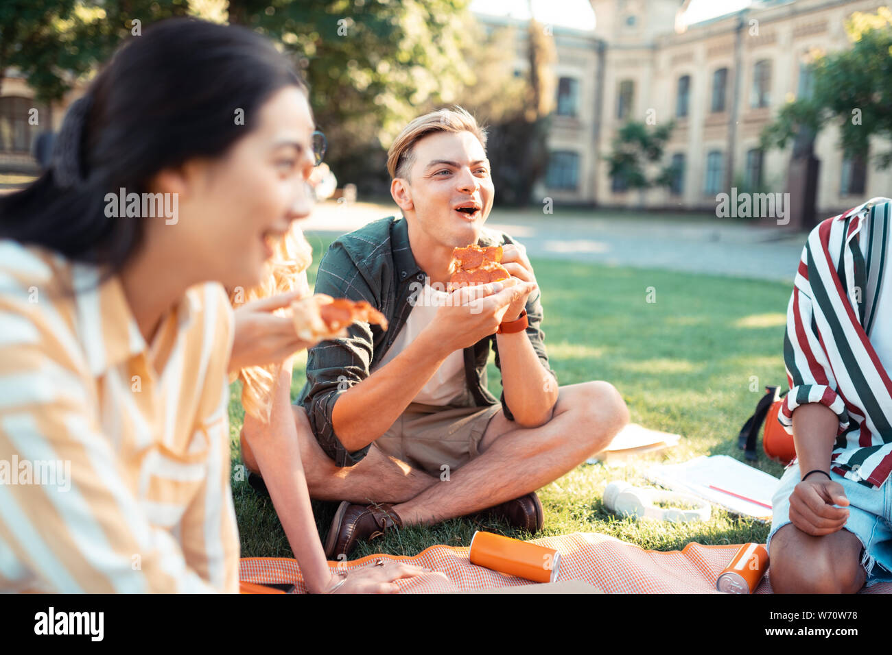 Cheerful boy laughing and eating his pizza Stock Photo - Alamy