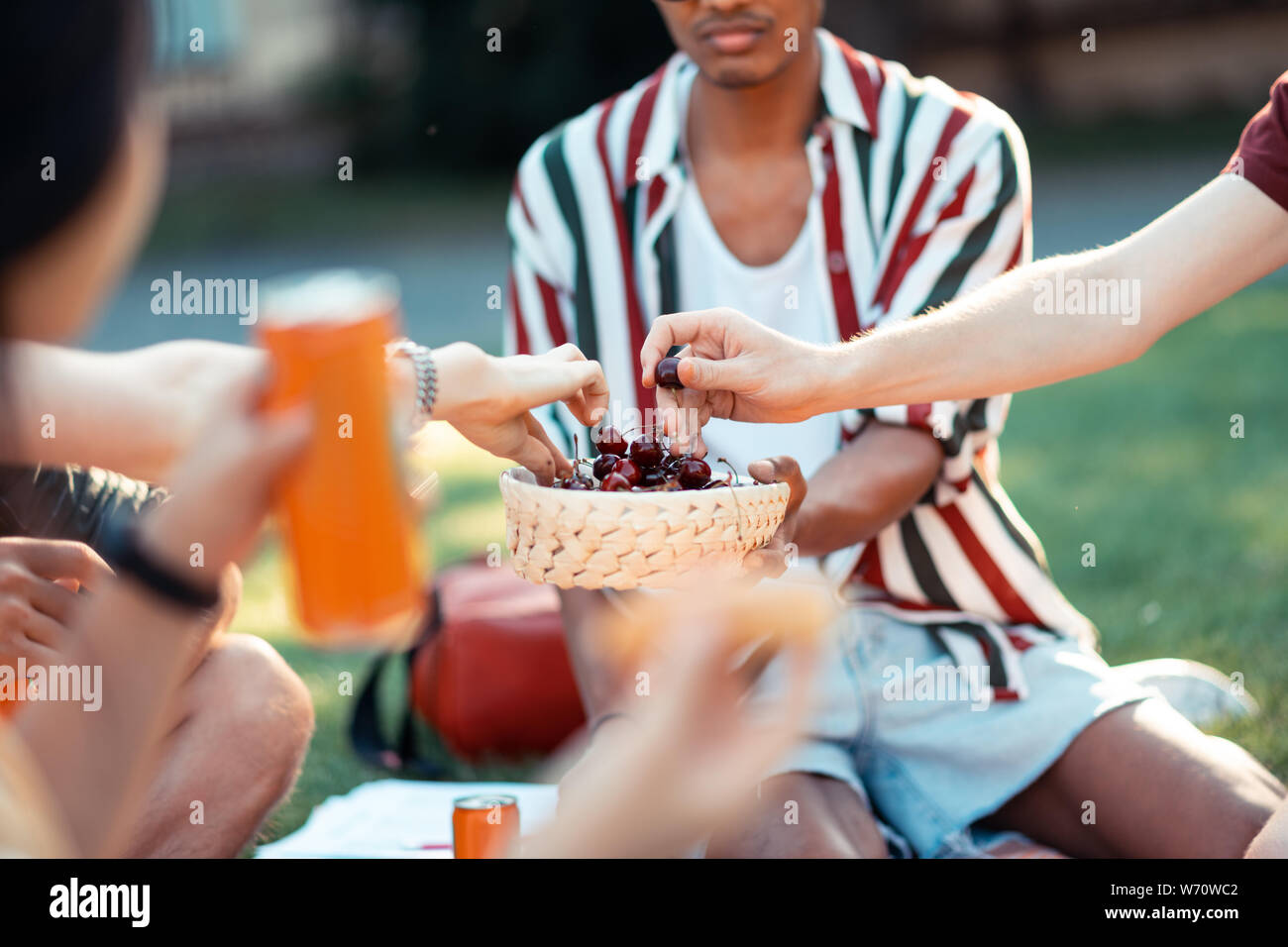 Friends eating cherries during their summer picnic Stock Photo - Alamy