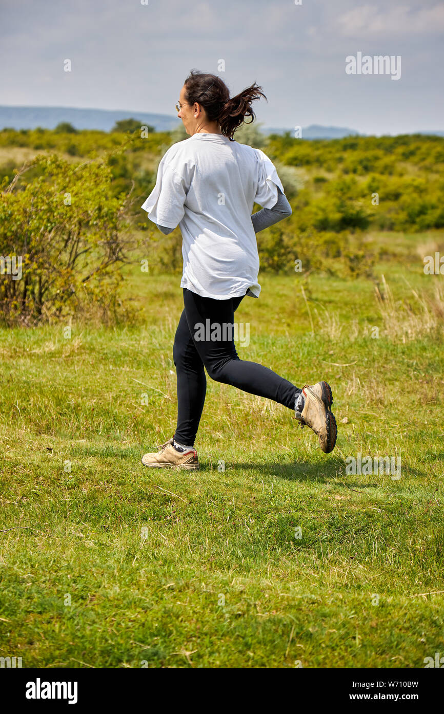 Spanish woman running on meadow Stock Photo - Alamy