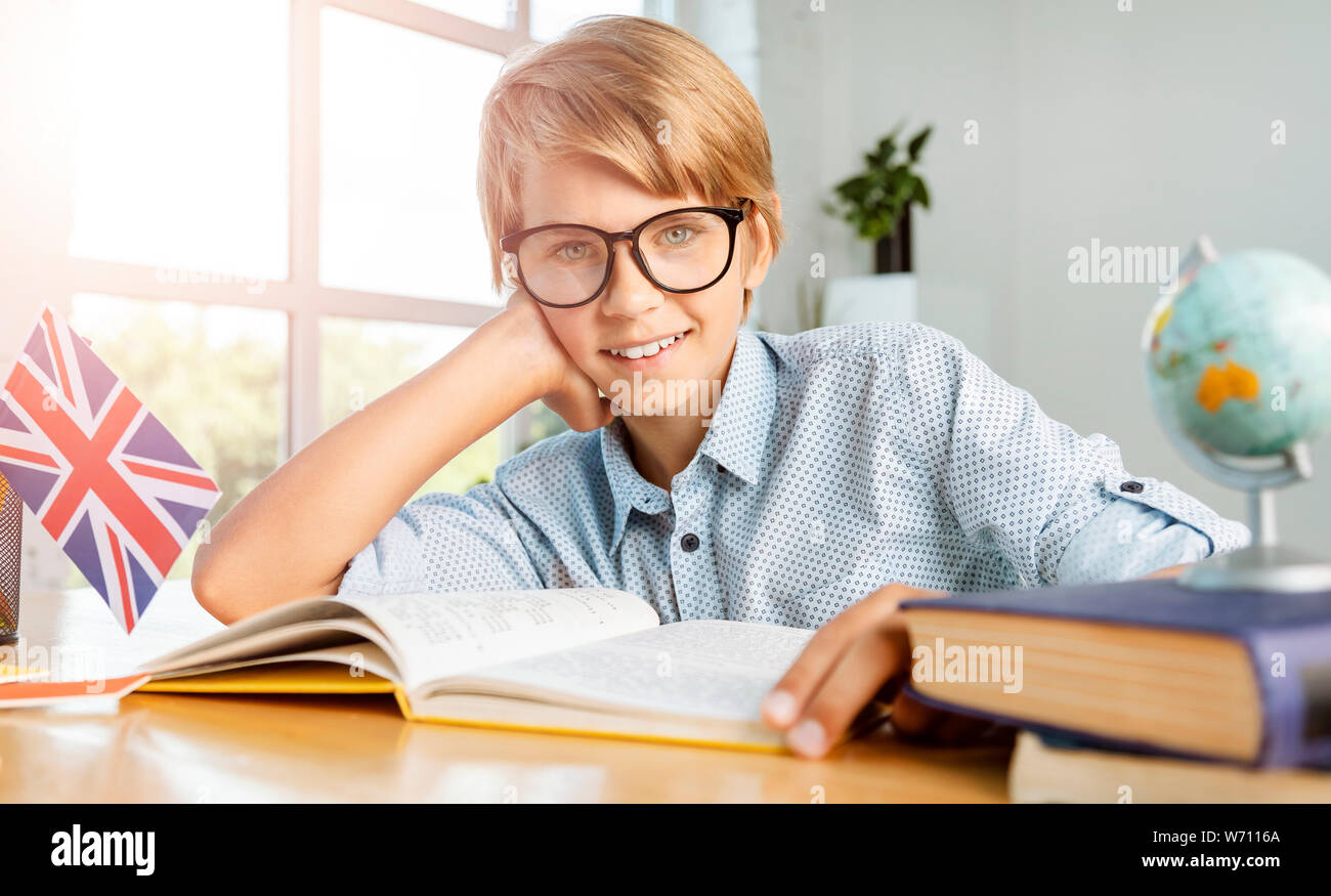 Portrait of teenage schoolboy wears smart eyeglasses sitting in the ...