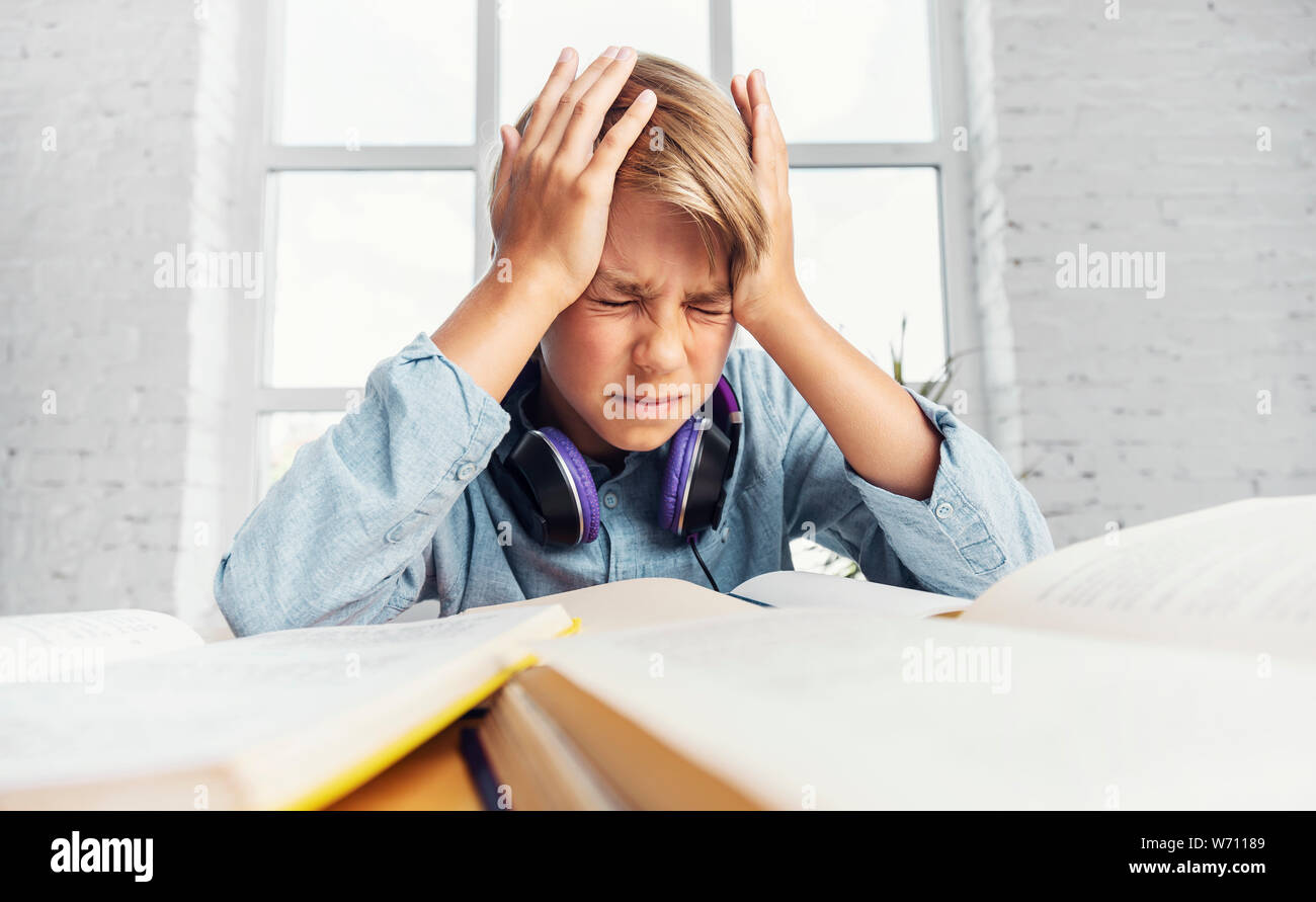 TIred schoolboy fells headache sitting in the classrooom Stock Photo ...