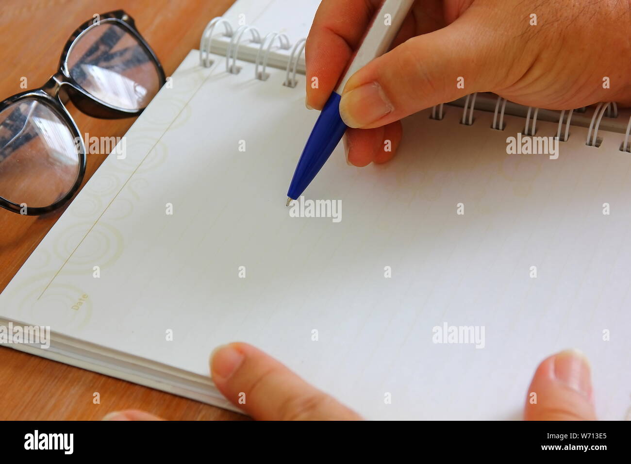 hand is writingdaily life on diary.business man using dairy to record ...