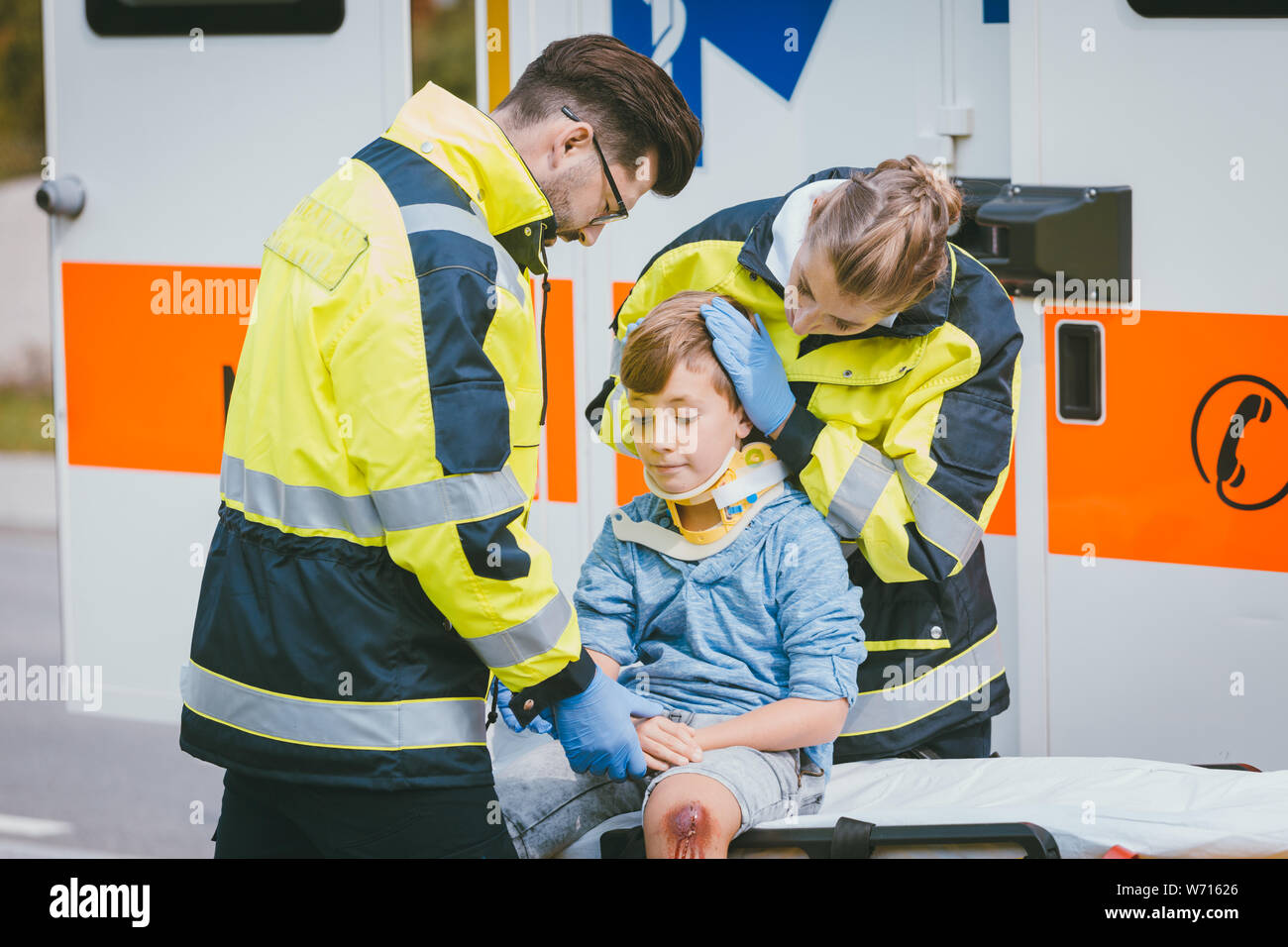 Boy is injured after accident, medics taking care of him Stock Photo ...