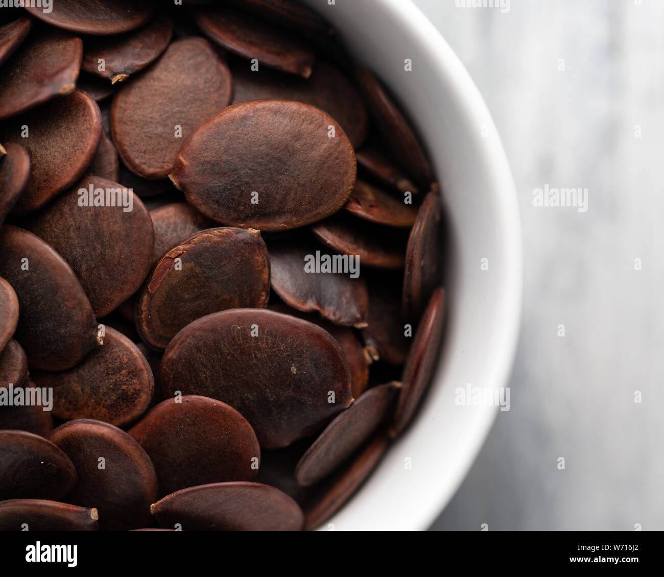Whole achi seeds in a white bowl, off centre to the left Stock Photo ...