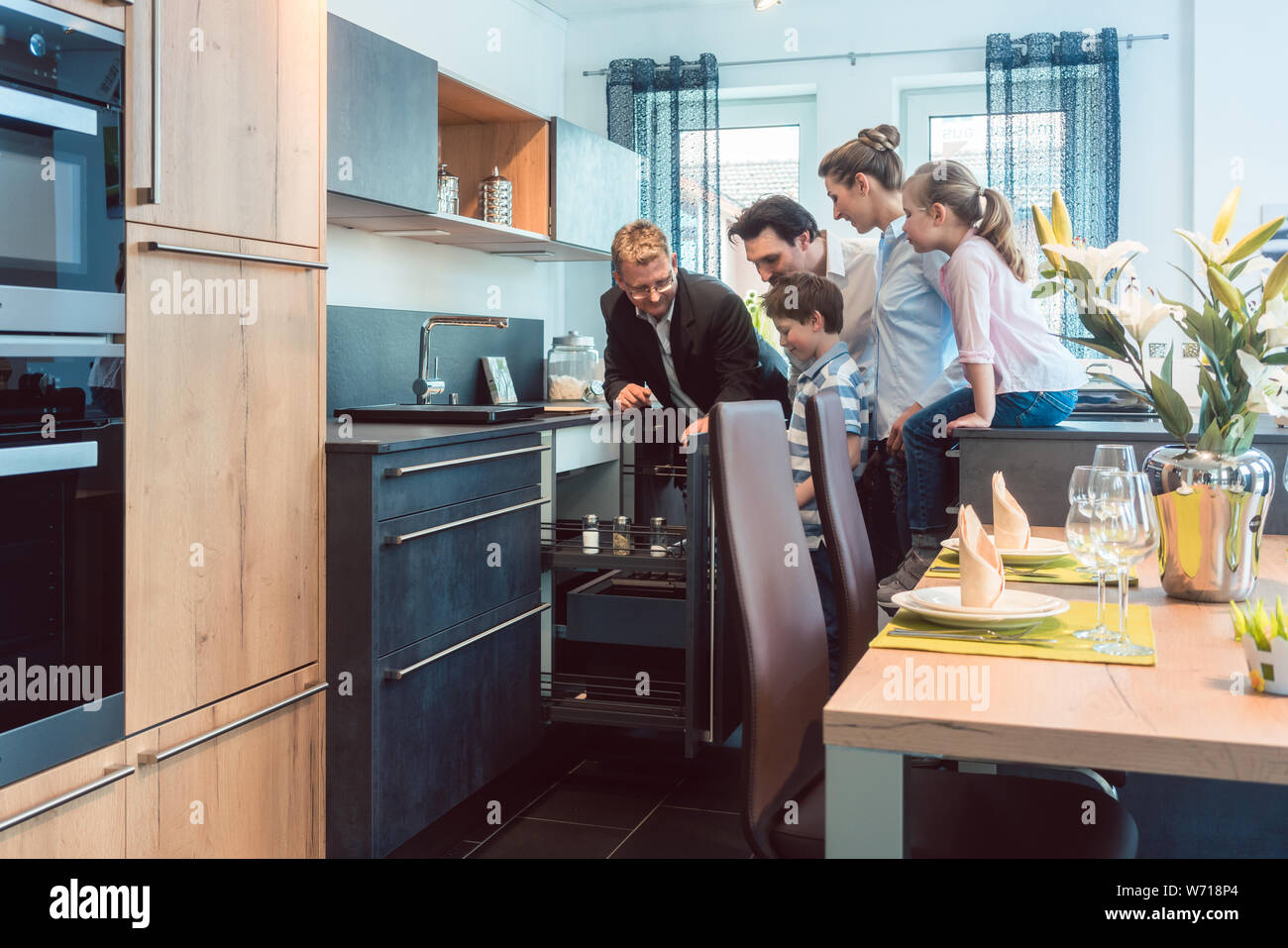 Family with kids looking at a kitchen in showroom Stock Photo - Alamy