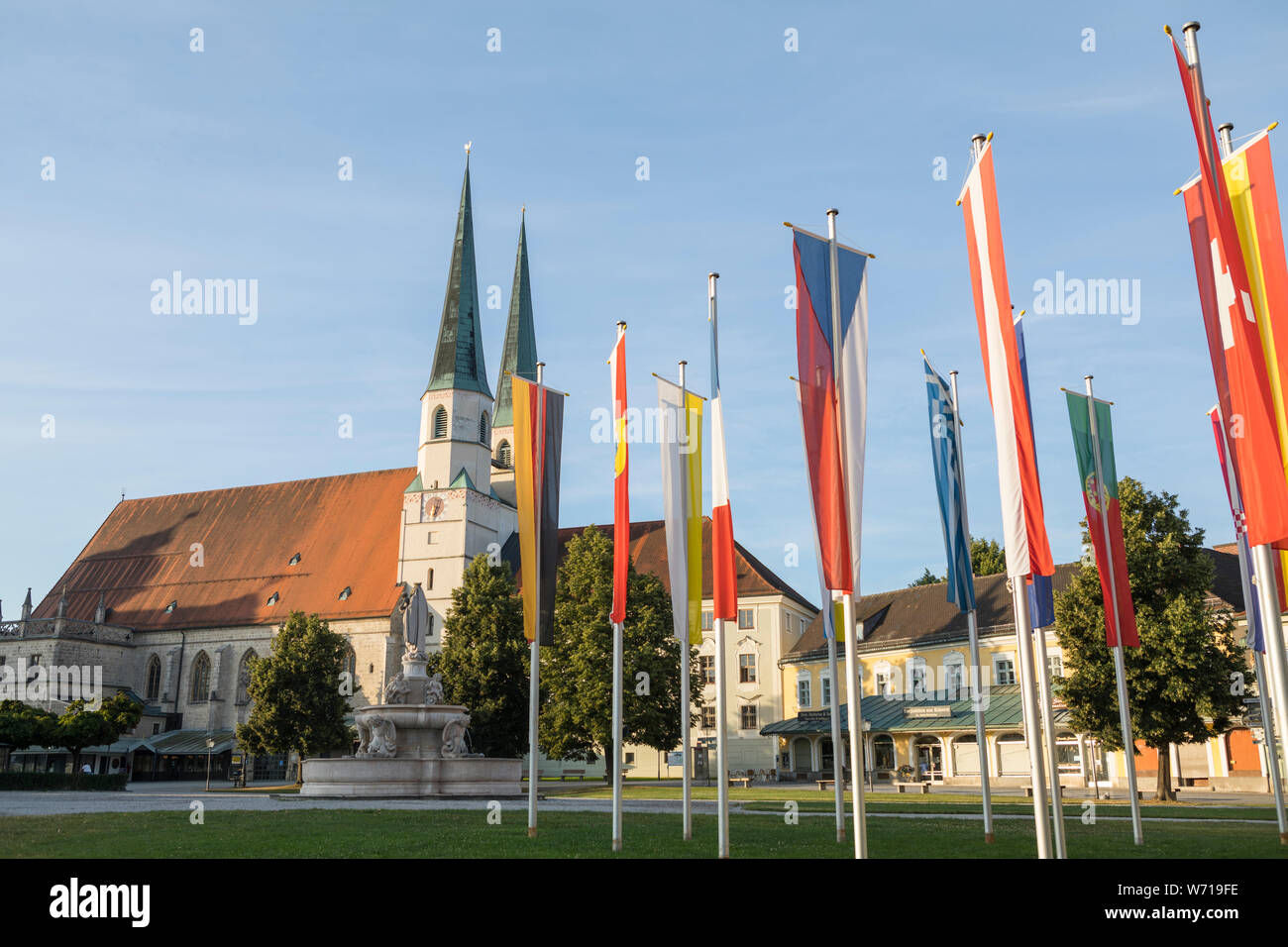 International flags waving in the wind in front of fountain and church ...