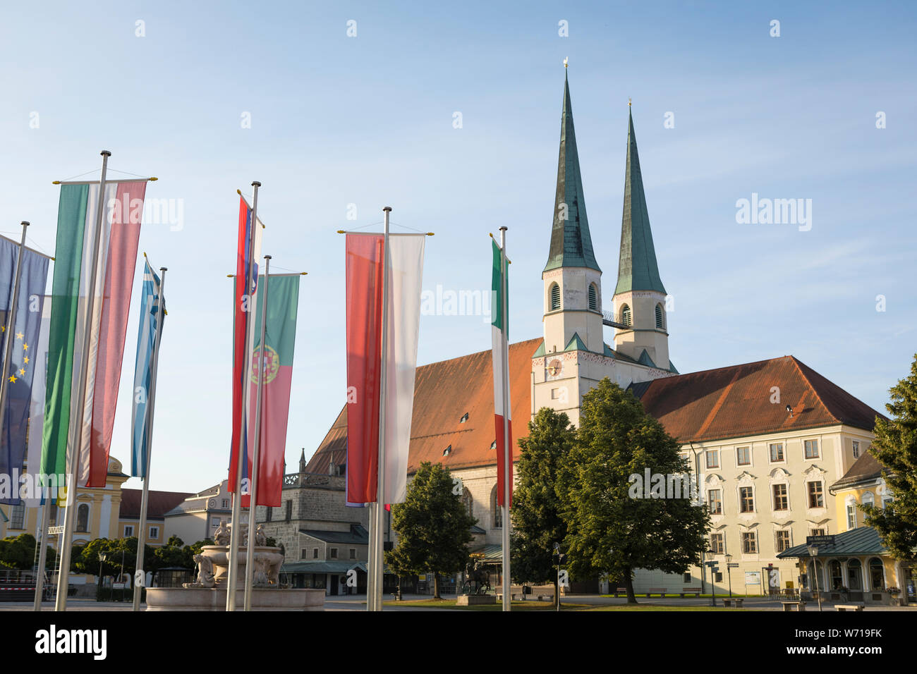 International flags waving in the wind in front of fountain and church ...