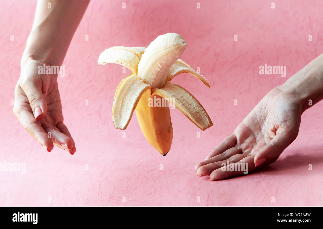open flying banana floating on pink background with womans hands Stock ...