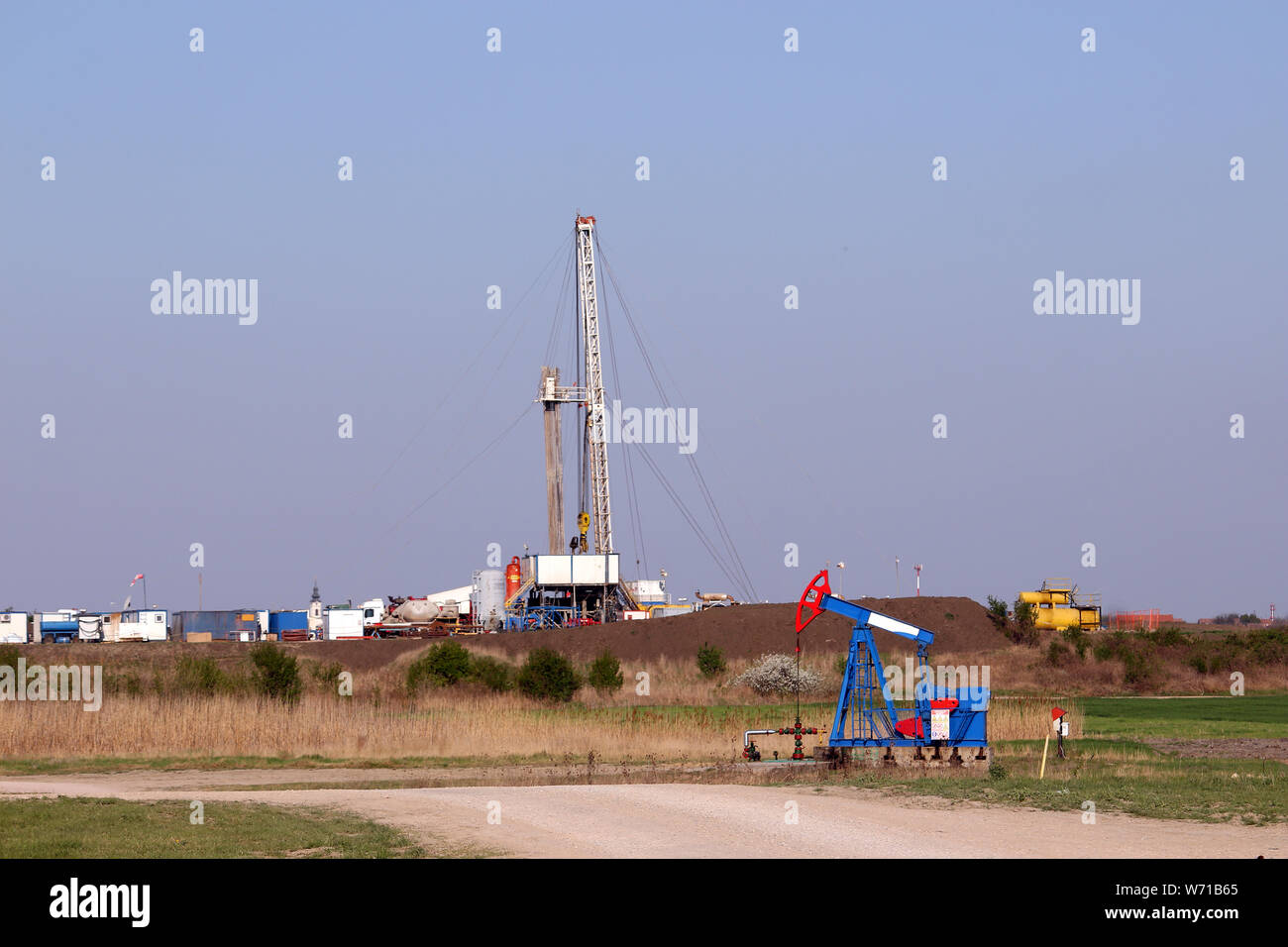 land oil and gas drilling rig and pump jack in oilfield mining industry ...