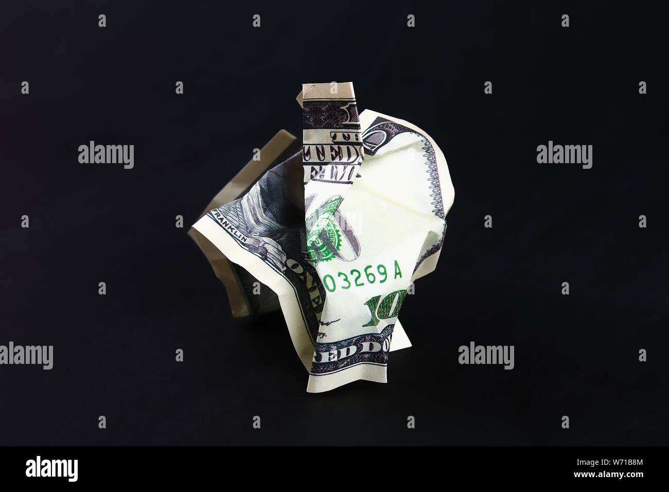 Crumpled one hundred American dollar on black paper background, close ...
