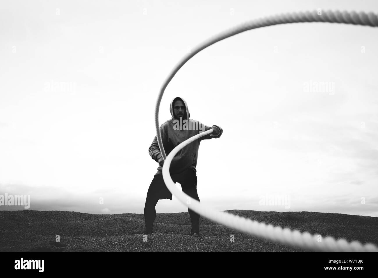 Strong fit athlete doing intens workout exercises using two battle ...