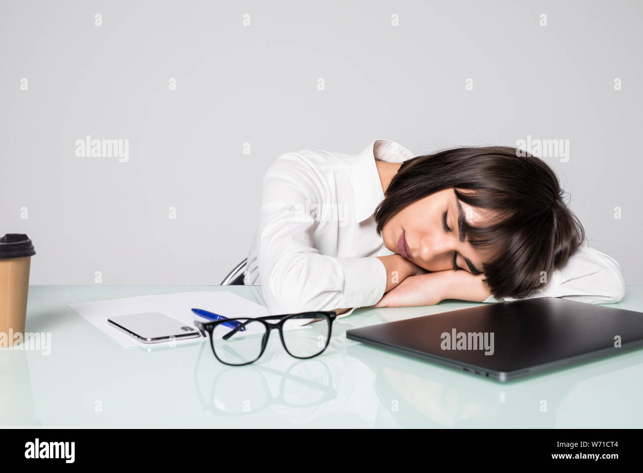Tired business woman sleeping on the desk, in front of the computer ...