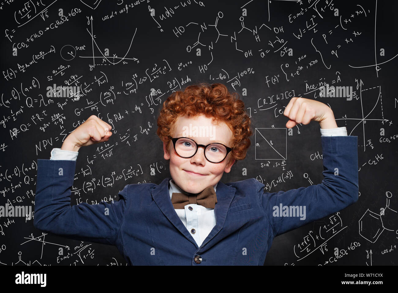 Happy strong child boy on chalkboard background. Back to school concept ...