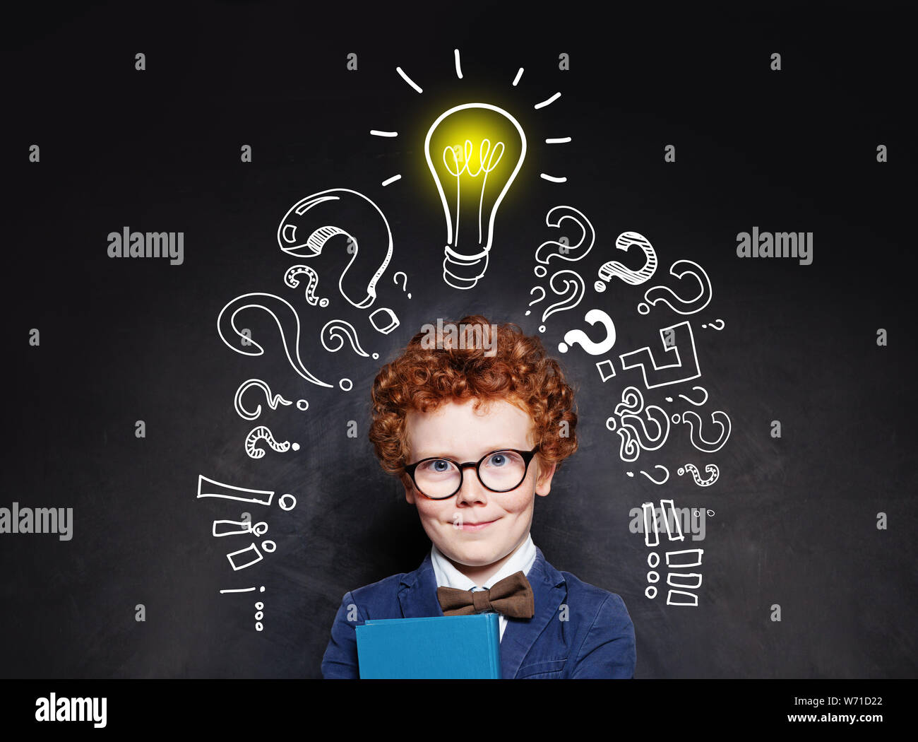Smart child boy in glasses smiling and holding book on background with ...