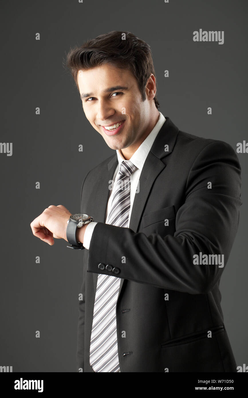Businessman checking the time with briefcase Stock Photo - Alamy