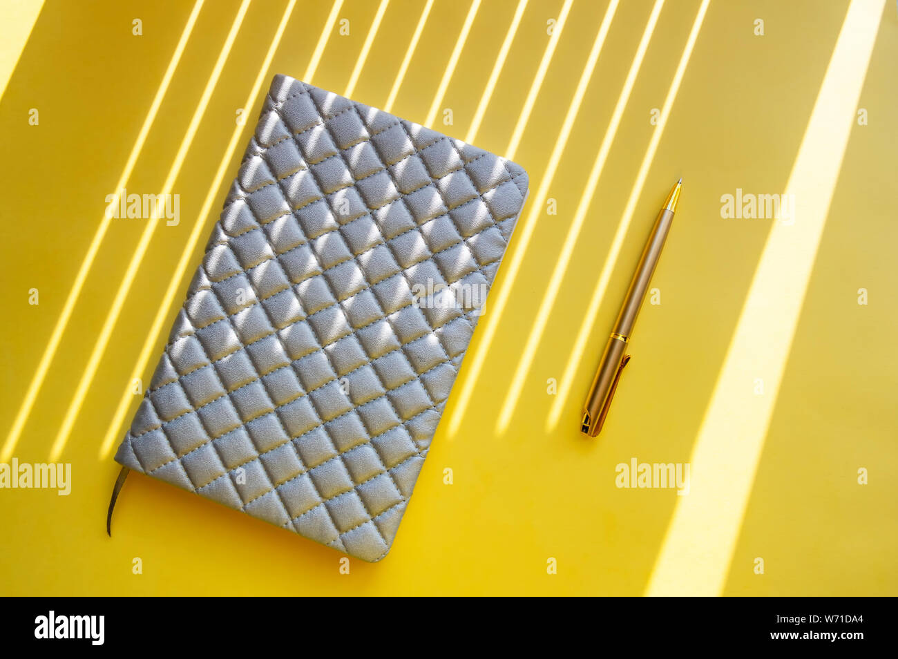 Notebook and pen on a yellow background. View from above. The concept ...