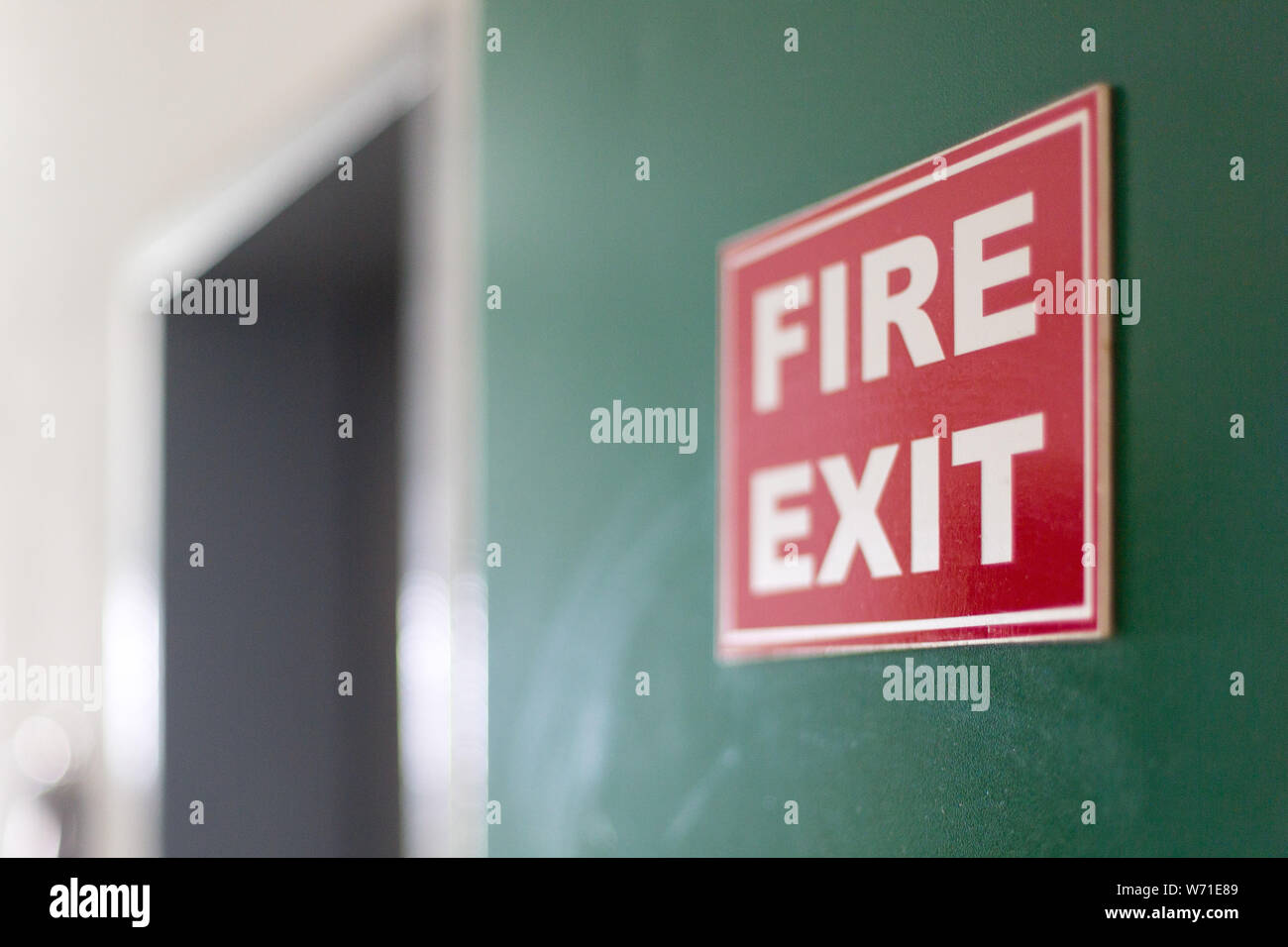 Fire exit sign mounted on the green wall of the corridor Stock Photo ...