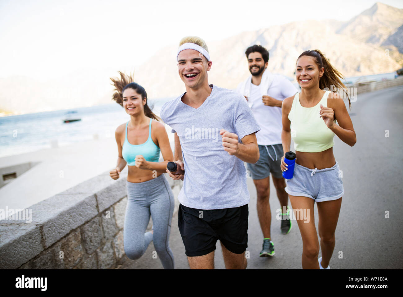 Outdoor portrait of group of friends running and jogging in nature ...