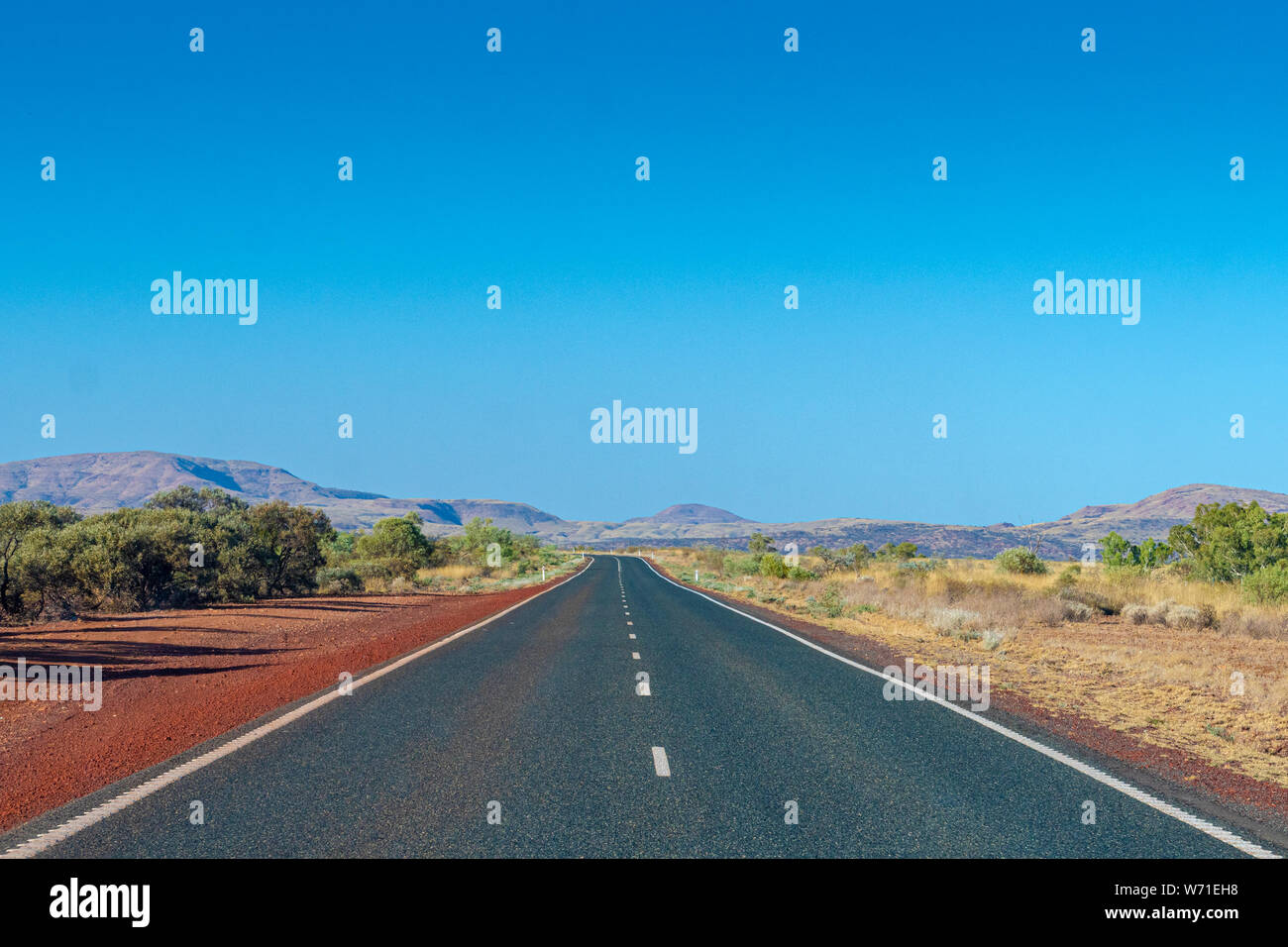 Dark tarmac road in Australian Outback around Cheela Plains Karijini ...