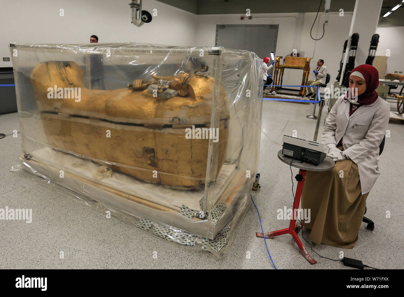 Giza, Egypt. 04th Aug, 2019. An Egyptian archaeologist works on the ...