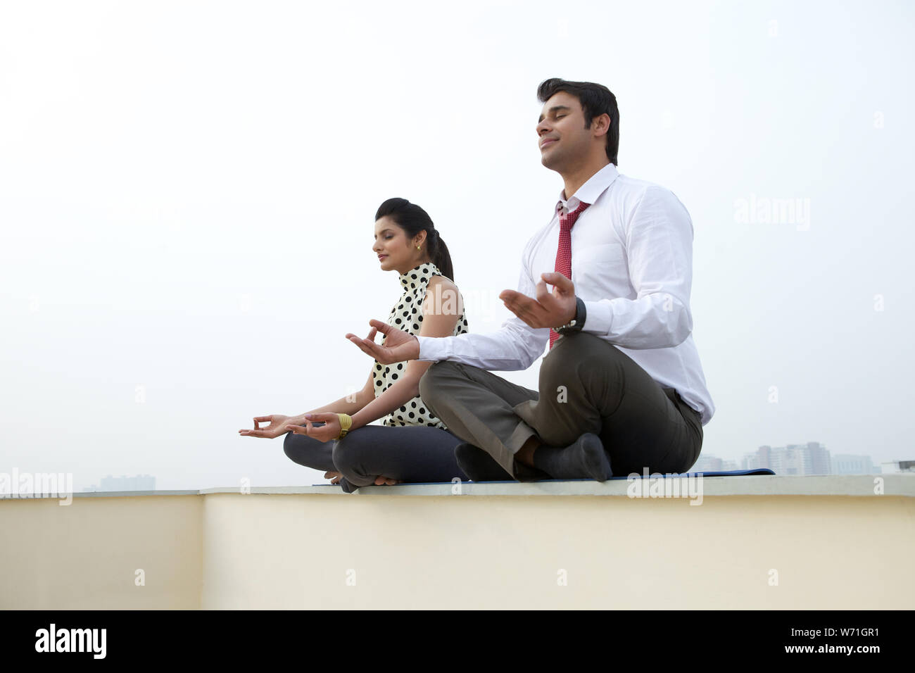 Two business executives walking on ledge Stock Photo - Alamy