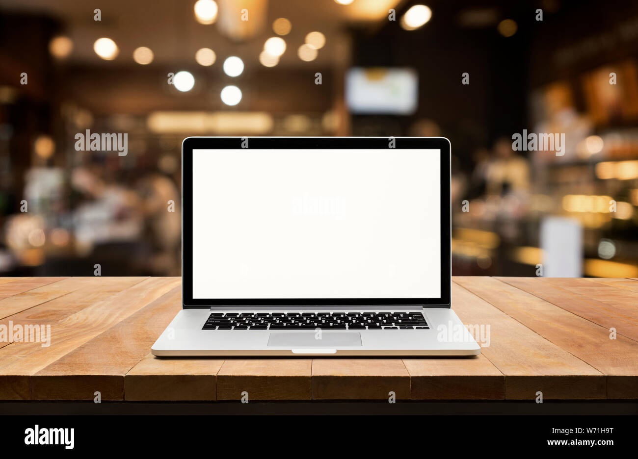 Modern computer,laptop with blank screen on table with blur cafe ...