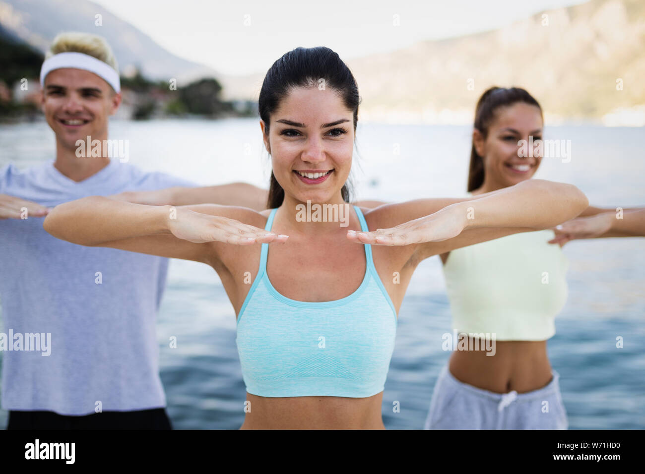 Group of happy people exercising outdoor. Sport, fitness, friendship ...