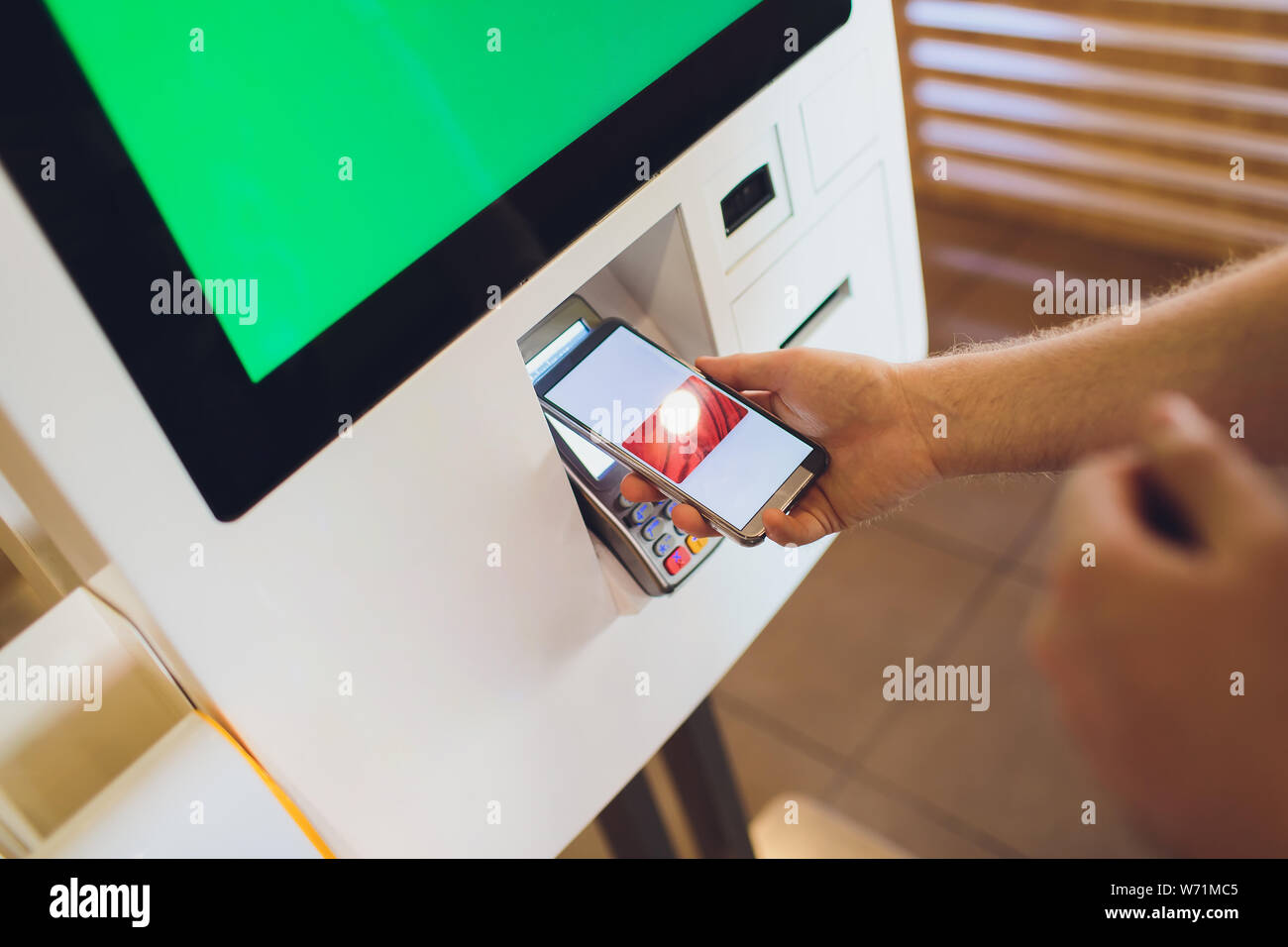 A man orders food in the touch screen terminal with electronic menu in ...