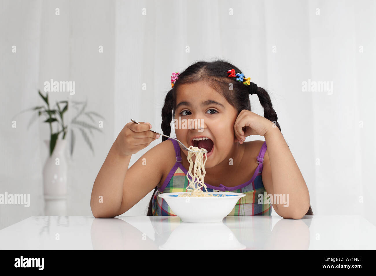 Girl eating noodles Stock Photo - Alamy
