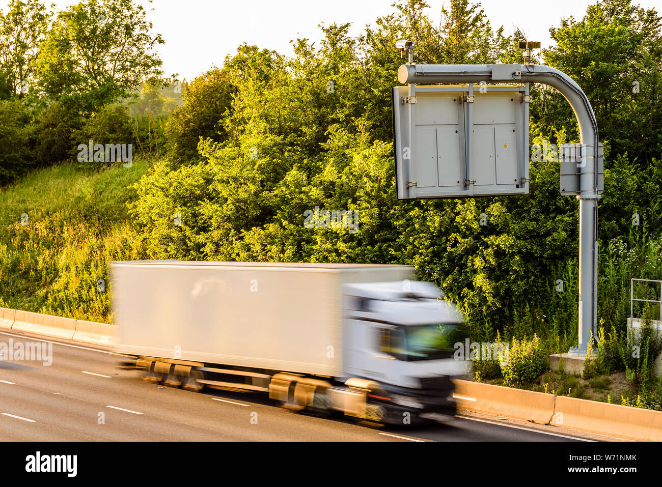 single lorry truck on uk motorway road under information display at ...