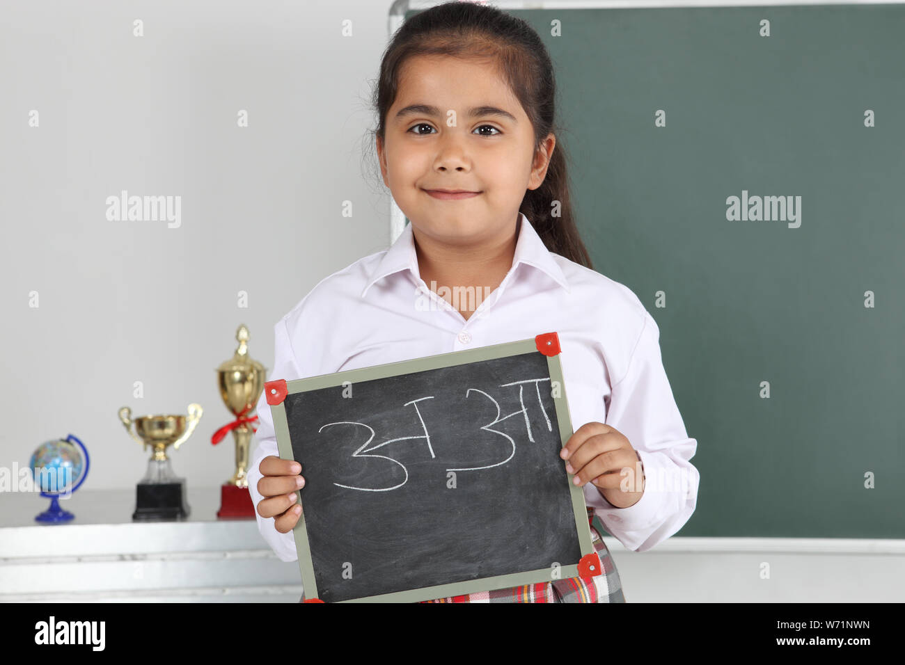 Schoolgirl showing a slate on which hindi alphabets written on it Stock ...