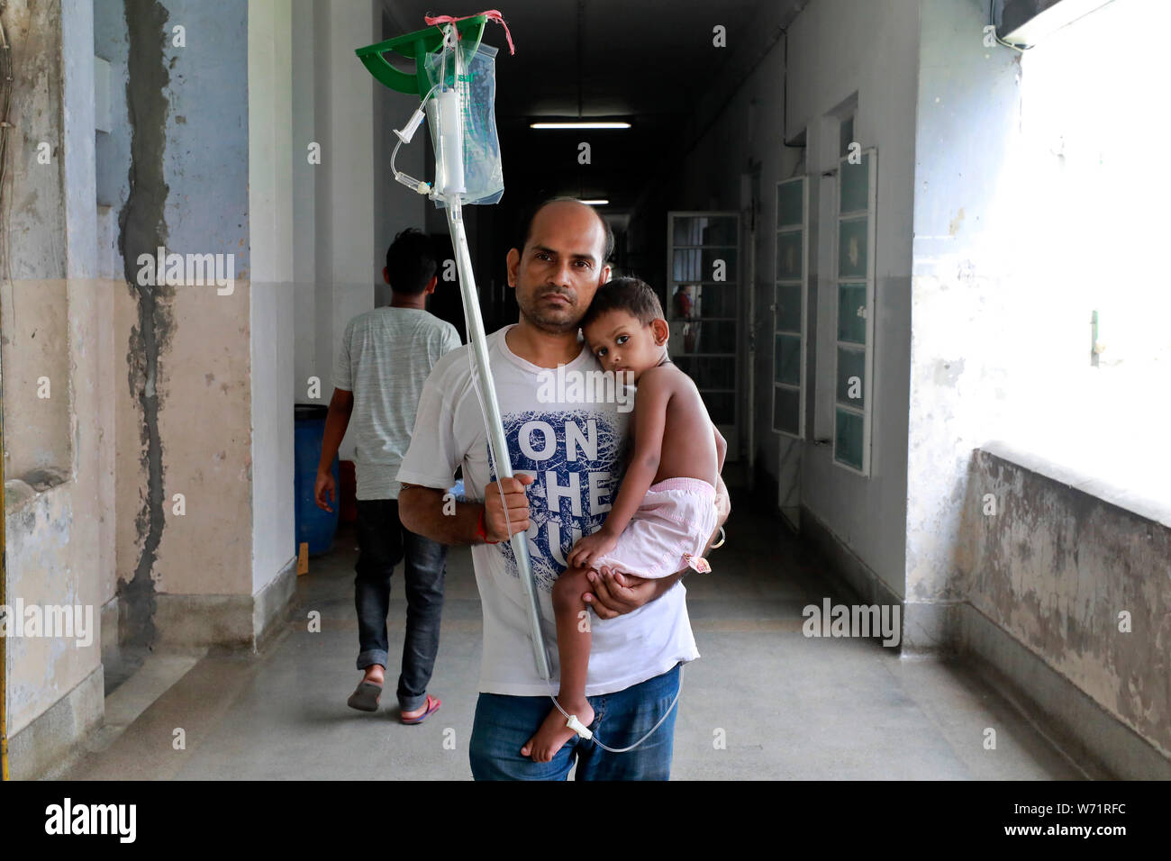 Dhaka, Bangladesh -August 04, 2019: The father cuddling a five year old dengue patient on the ...