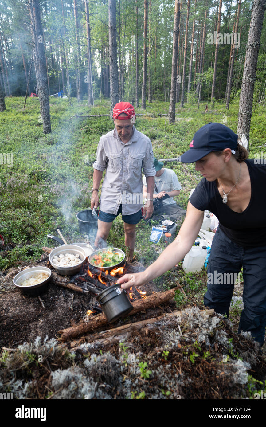 Friends wild camping in a forest Stock Photo - Alamy