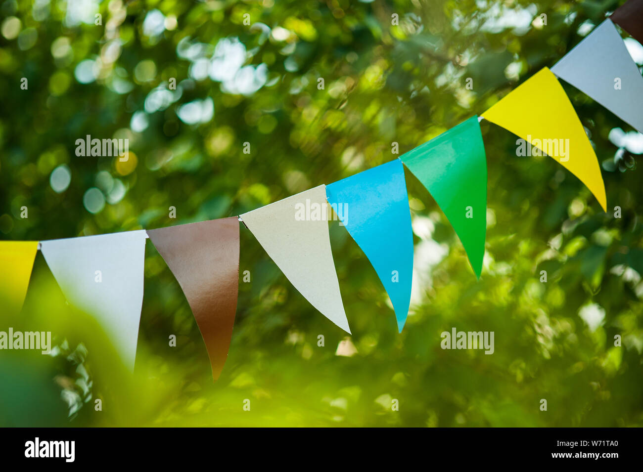 Garland of paper flags on a tree Stock Photo - Alamy