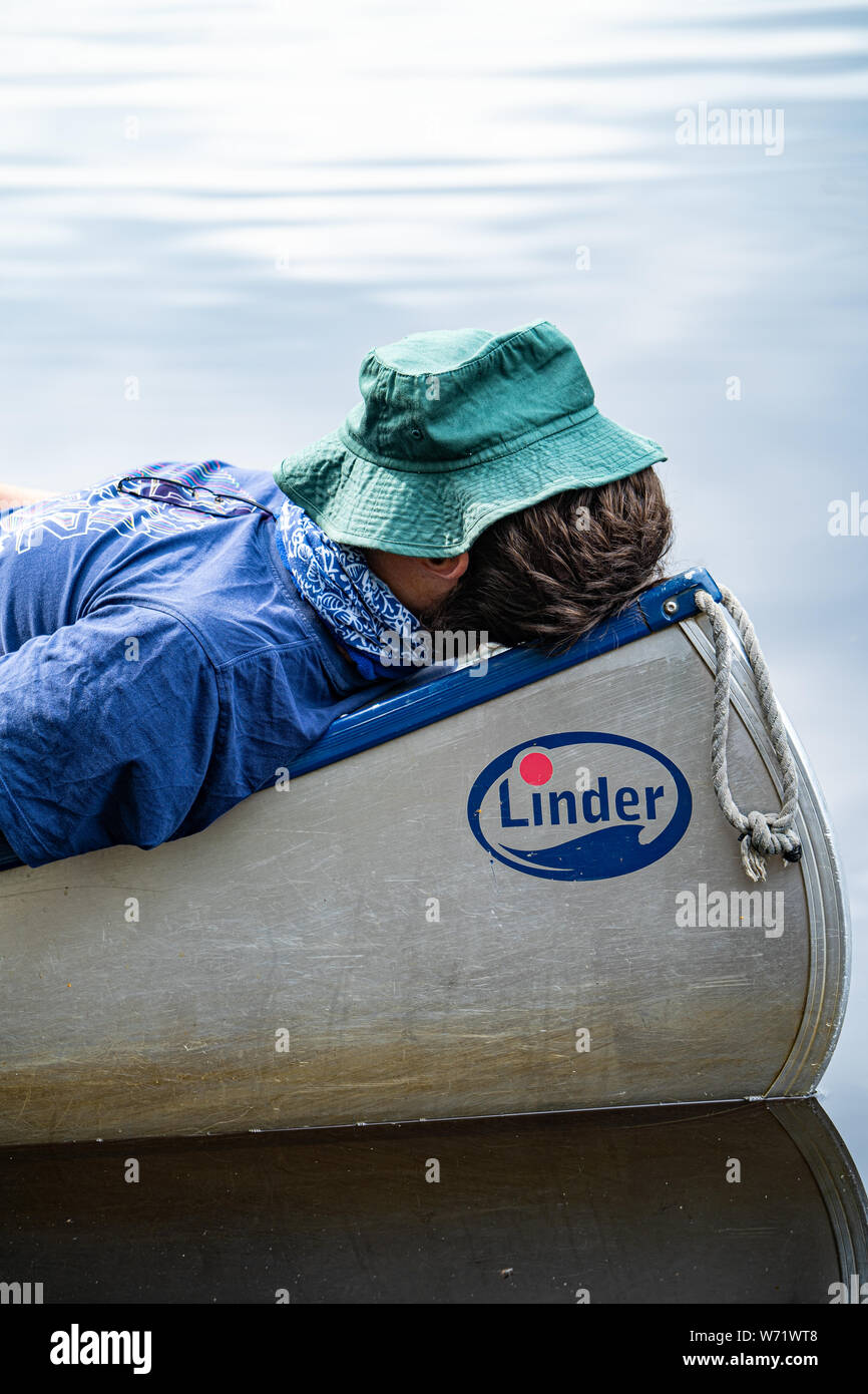 Male canoeist relaxing on a canoe journey on the Black river ...