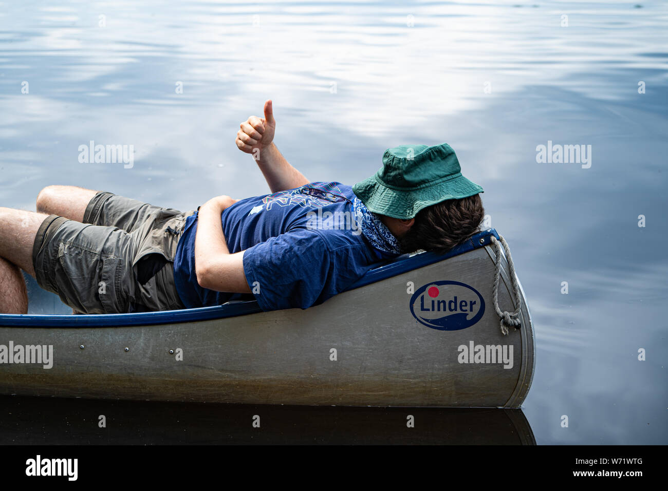 Male canoeist relaxing on a canoe journey on the Black river ...