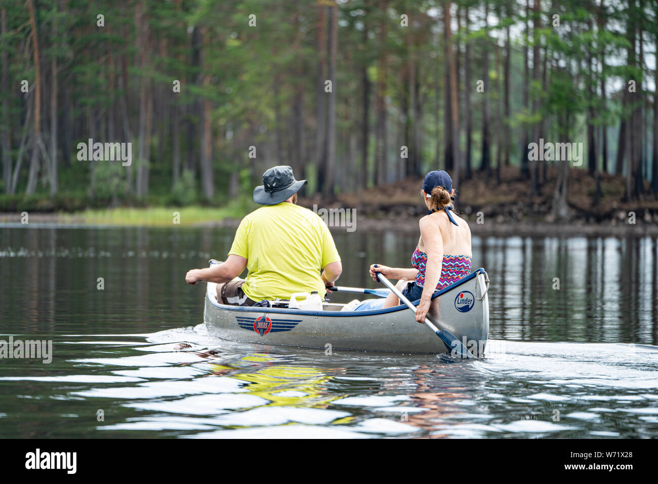 Two people (a man and a woman) canoeing on the Black River (Svartälven ...