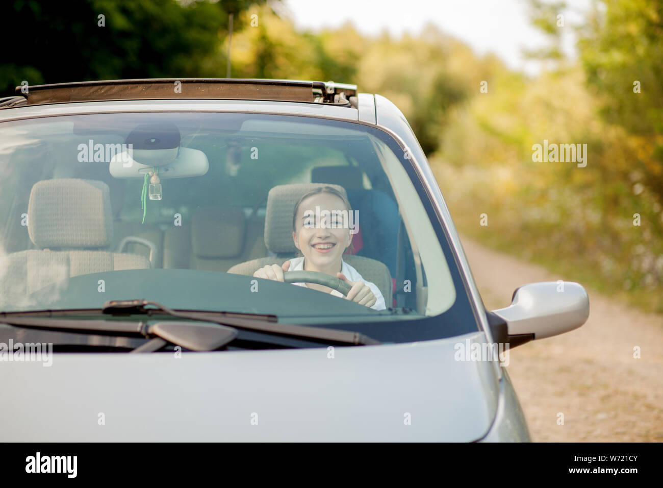 Portrait shot through windshield of pretty woman in car Stock Photo - Alamy