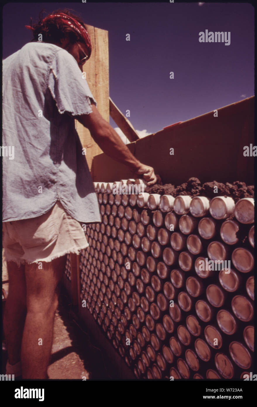 CONSTRUCTION OF ONE OF THREE EXPERIMENTAL HOUSES BUILT FROM EMPTY BEER ...