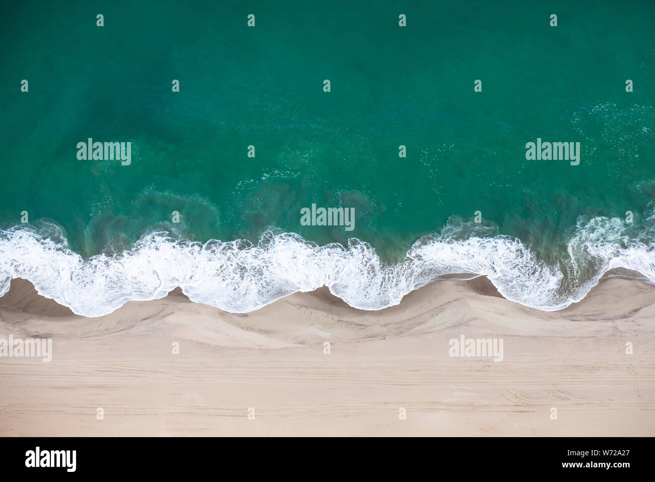 Aerial view of Skeleton coast sand dunes meeting the waves of Atlanic ...