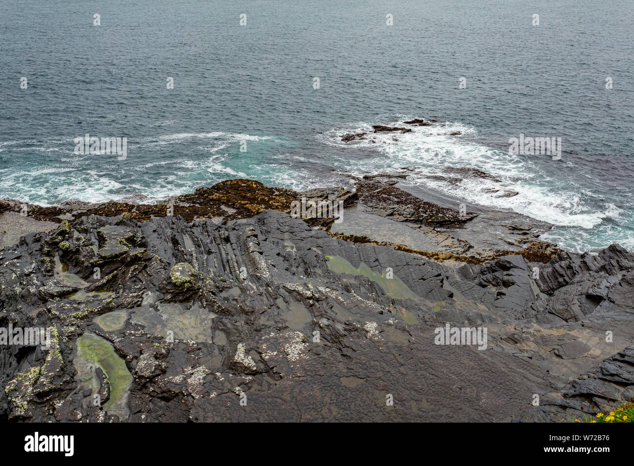 View of the limestone pavement and the sea along the coastal walk route ...