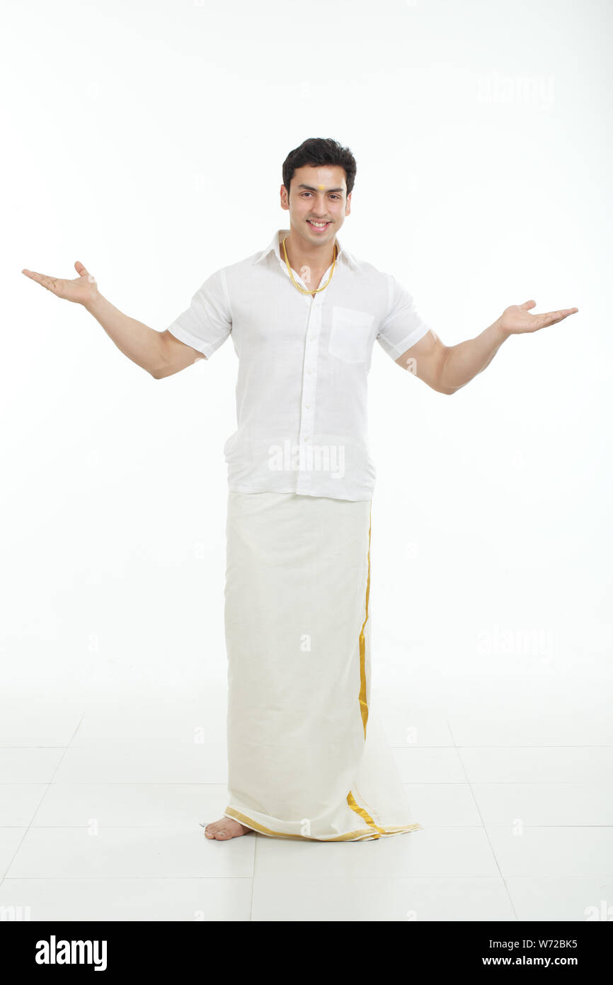 South Indian man smiling with his arm outstretched Stock Photo - Alamy