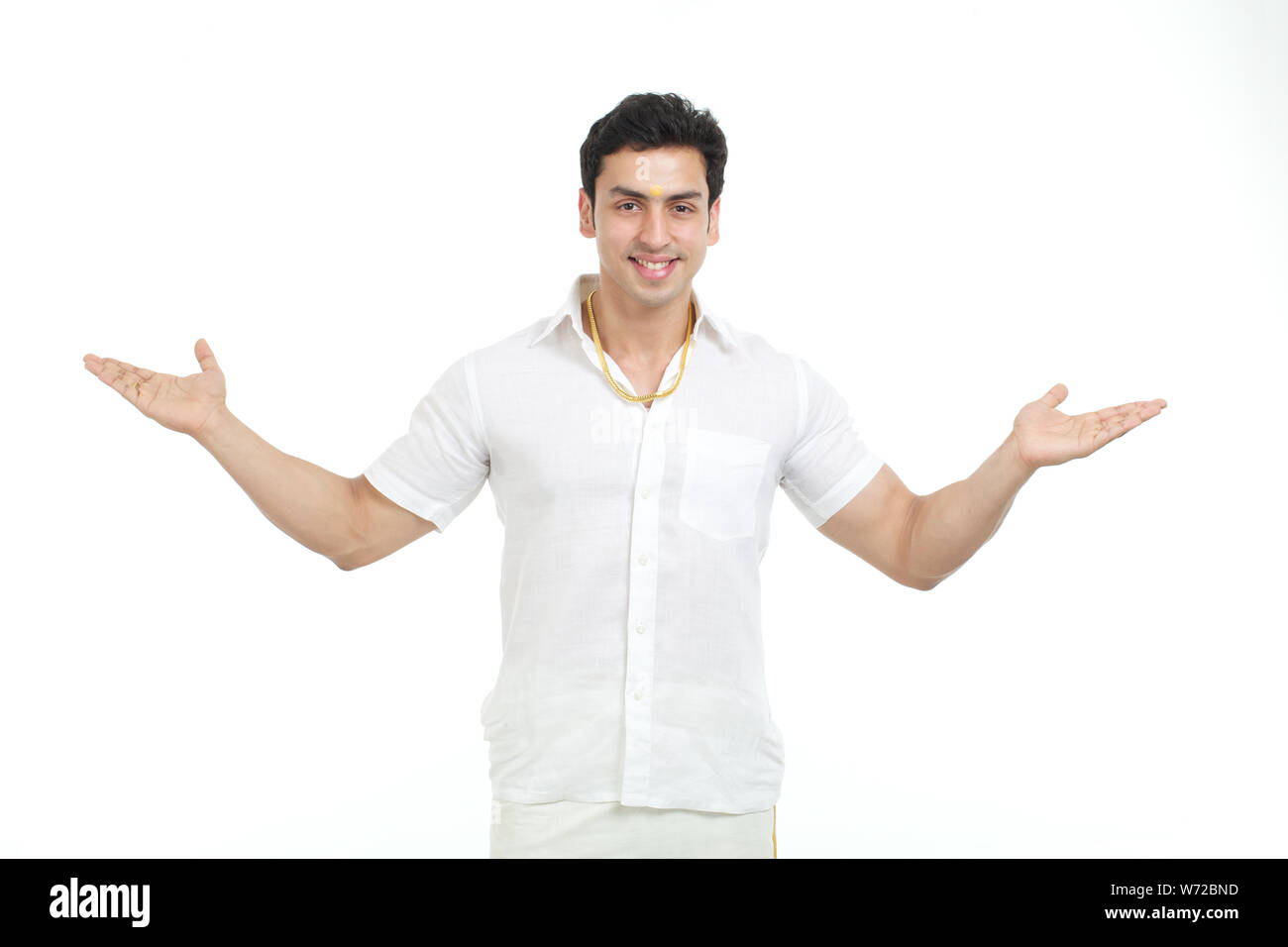 South Indian man smiling with his arm outstretched Stock Photo - Alamy