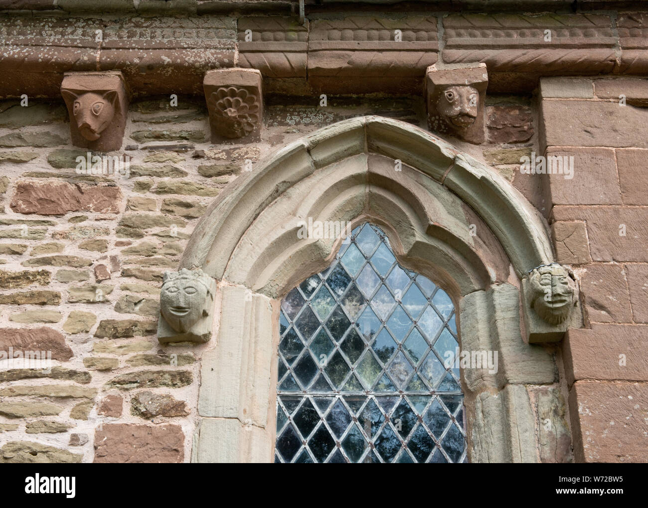 Corbel carvings of male human and animal heads and flowers near south ...