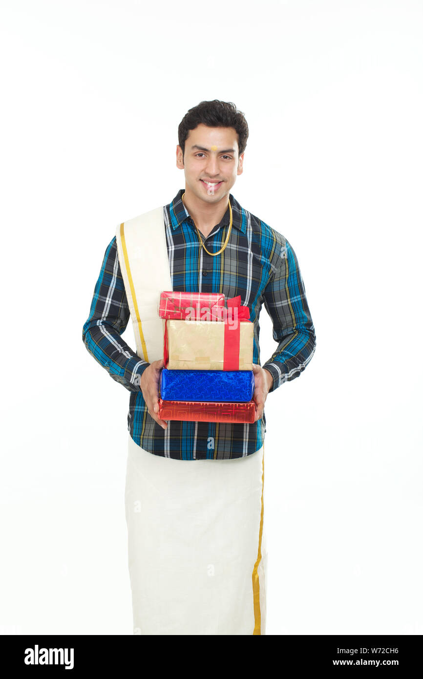 South Indian man holding gift boxes and smiling Stock Photo - Alamy