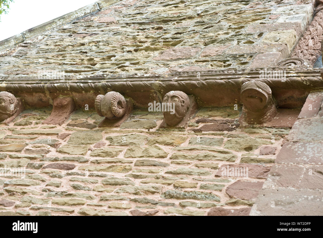 Corbel carvings of male heads and sheep ram around eaves of Church of ...