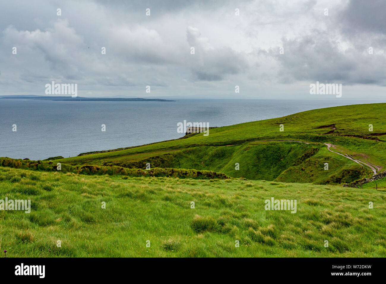 Seascape and a rural trail between the Irish countryside of the coastal ...