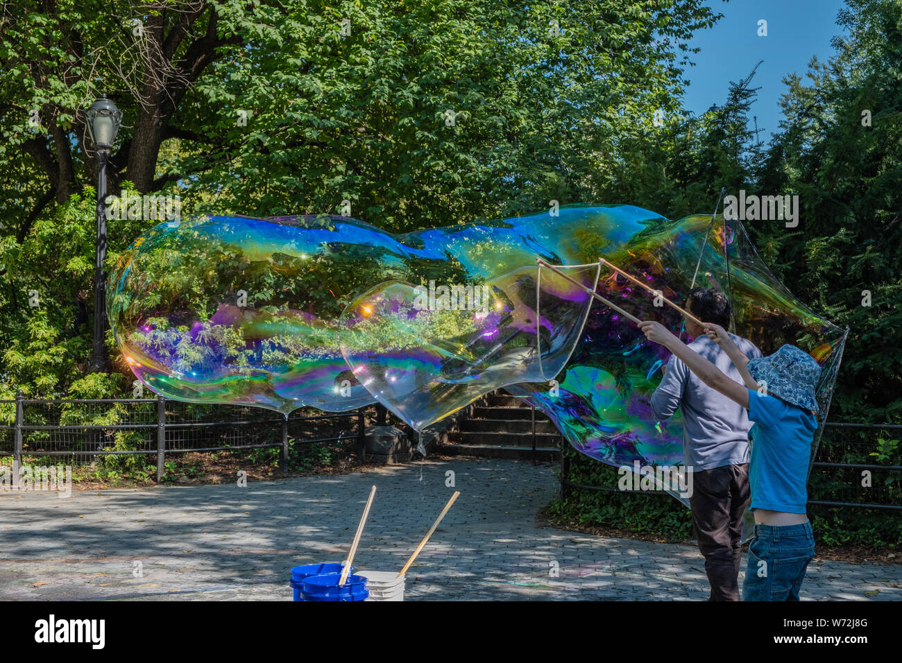 A man and child making giant bubbles Stock Photo - Alamy
