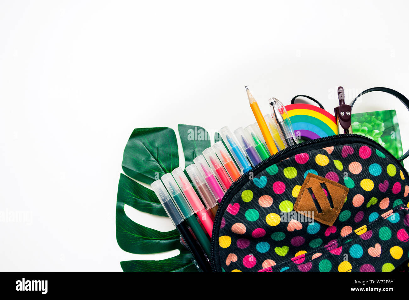 Bright colored backpack and colorful stationary school supplies on ...