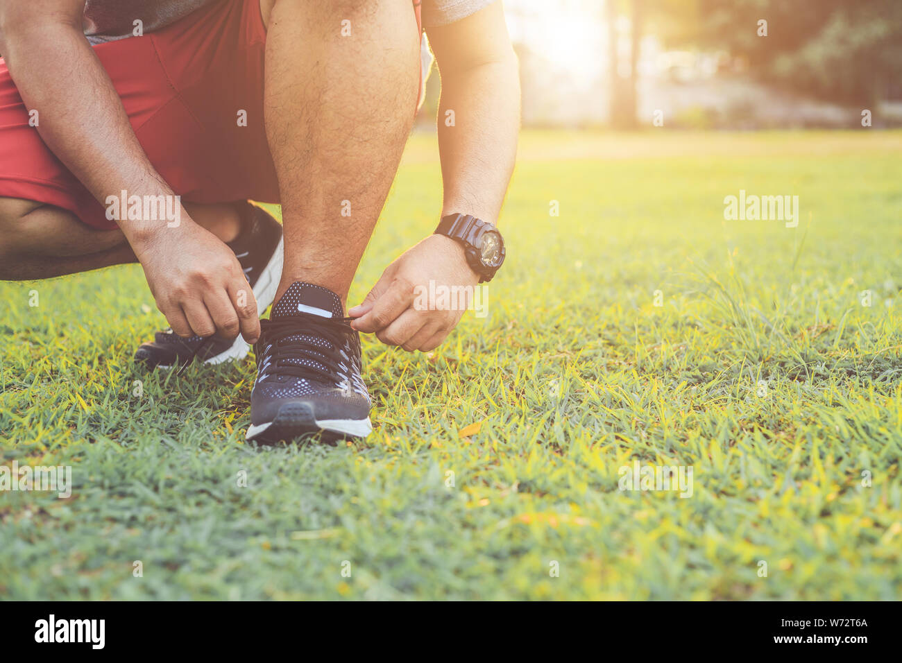 Close up man tying rope on his sports shoe. Preparing for run in the ...